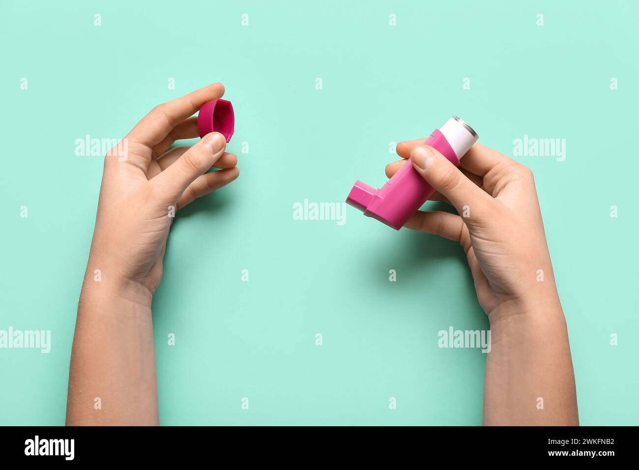 Child's hands with asthma inhaler on turquoise background Stock Photo ...