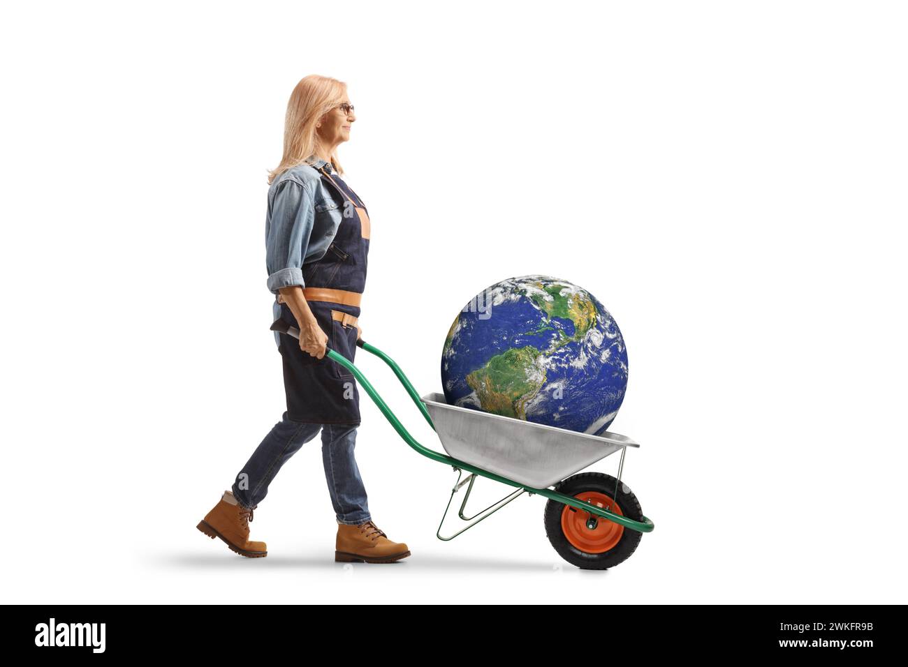 Full length profile shot of a woman pushing a wheelbarrow with the ...