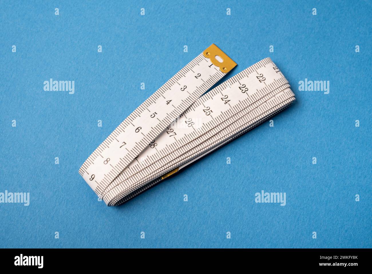 A tailor's meter on a blue background, symbolizing custom clothing ...