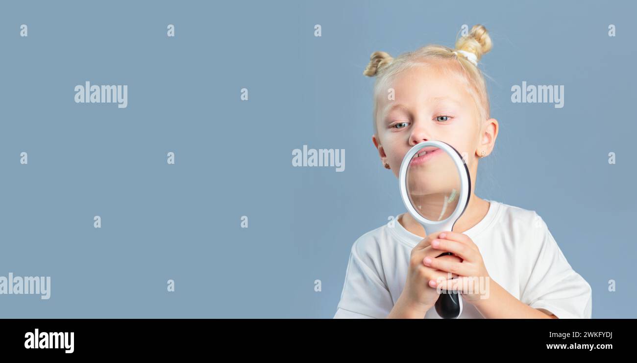 Curious school girl playing with magnifying glass Stock Photo - Alamy