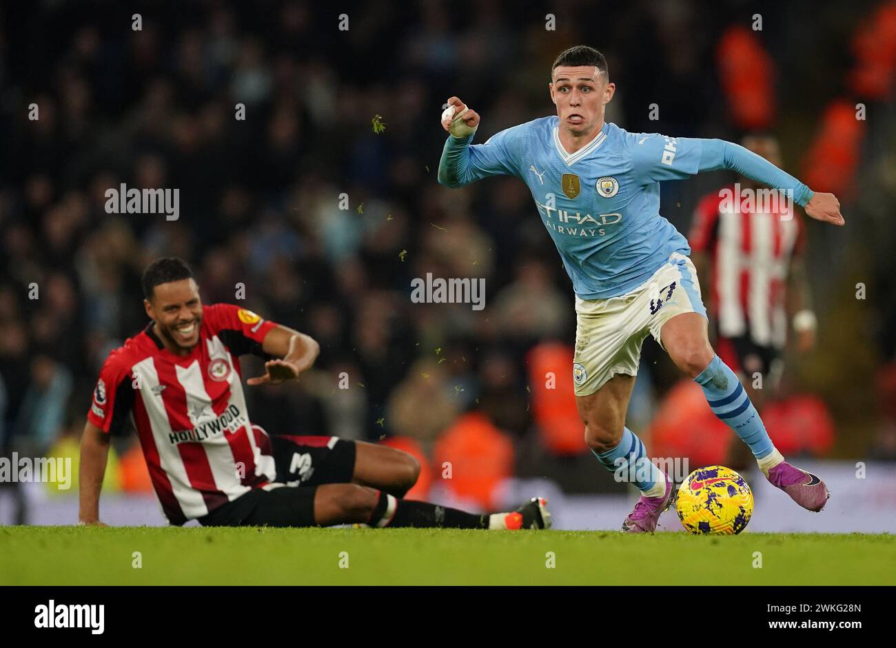 Manchester City's Phil Foden (right) gets past Brentford's Mathias ...