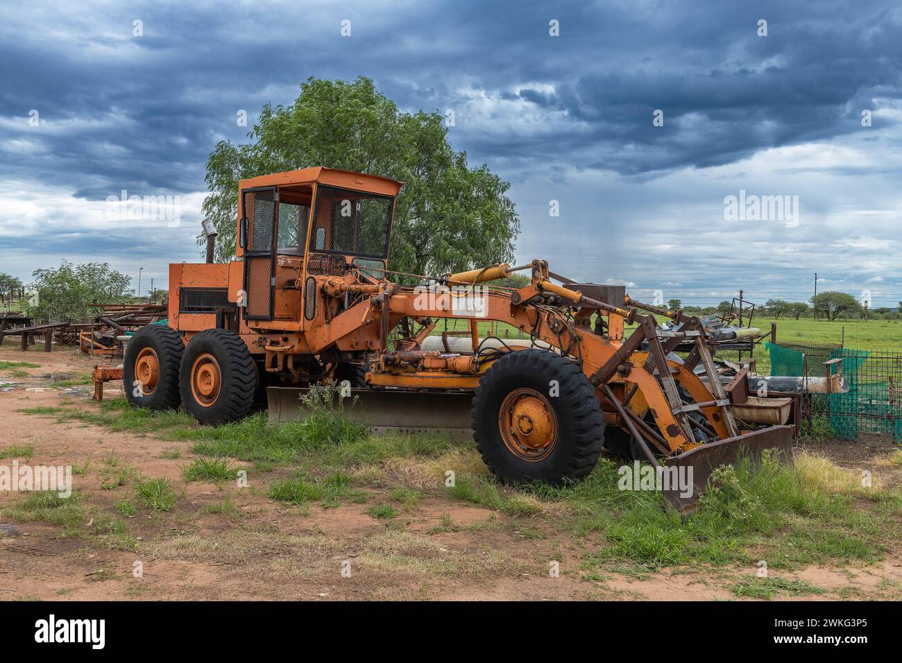 Orange grader parked on the side of a road, Namibia Stock Photo - Alamy