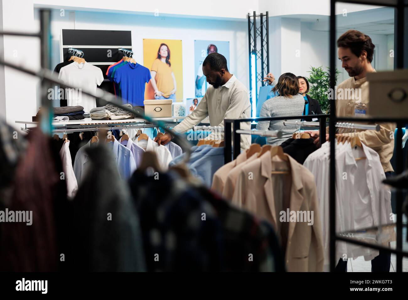 African american man shopping for shirt in crowded clothing store while ...
