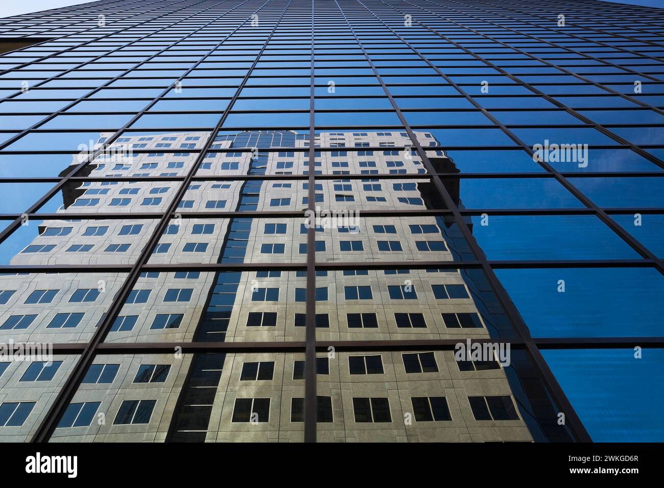 Modern architectural building reflected in another modern glass and ...
