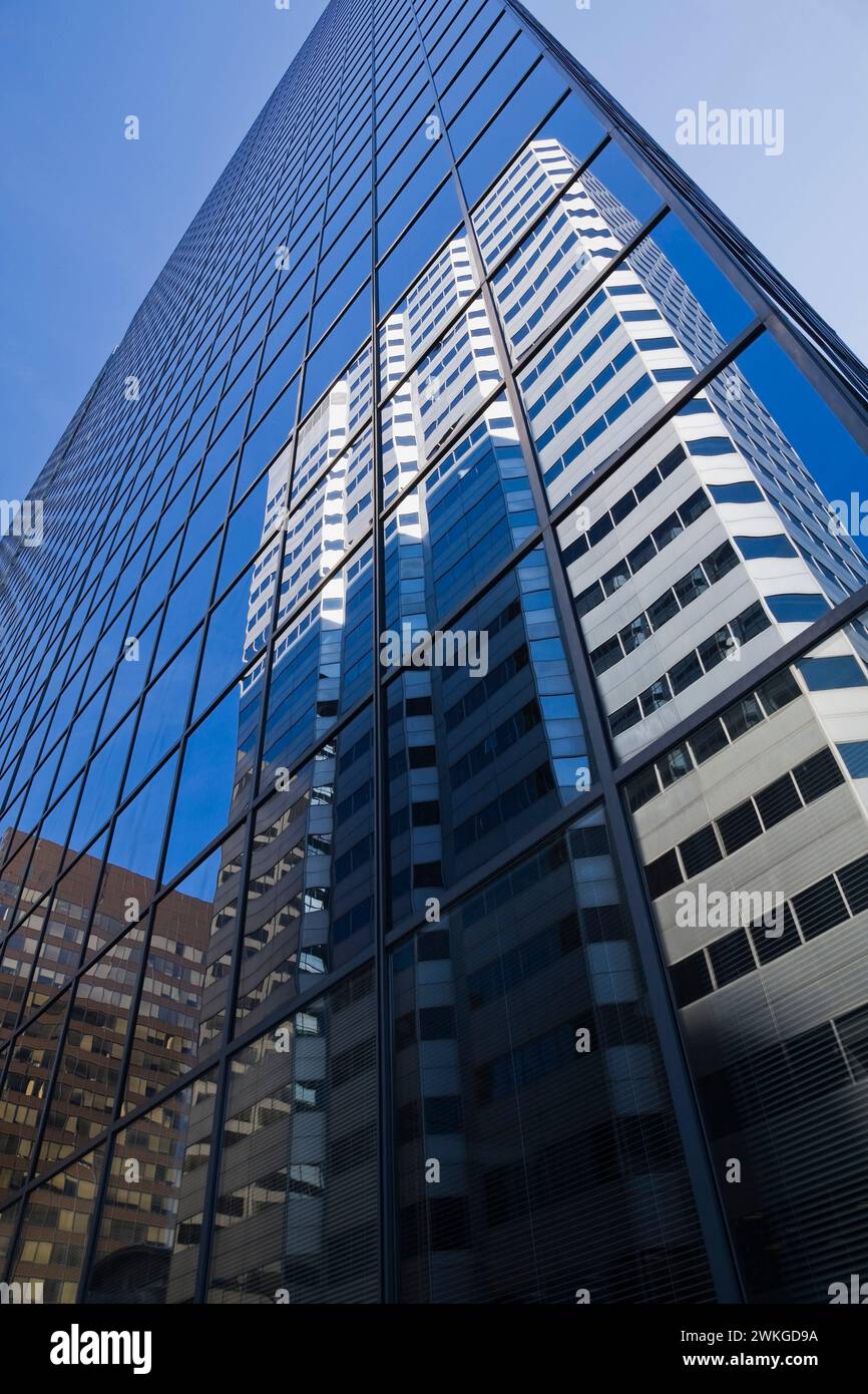 Modern architectural building reflected in another modern glass and ...