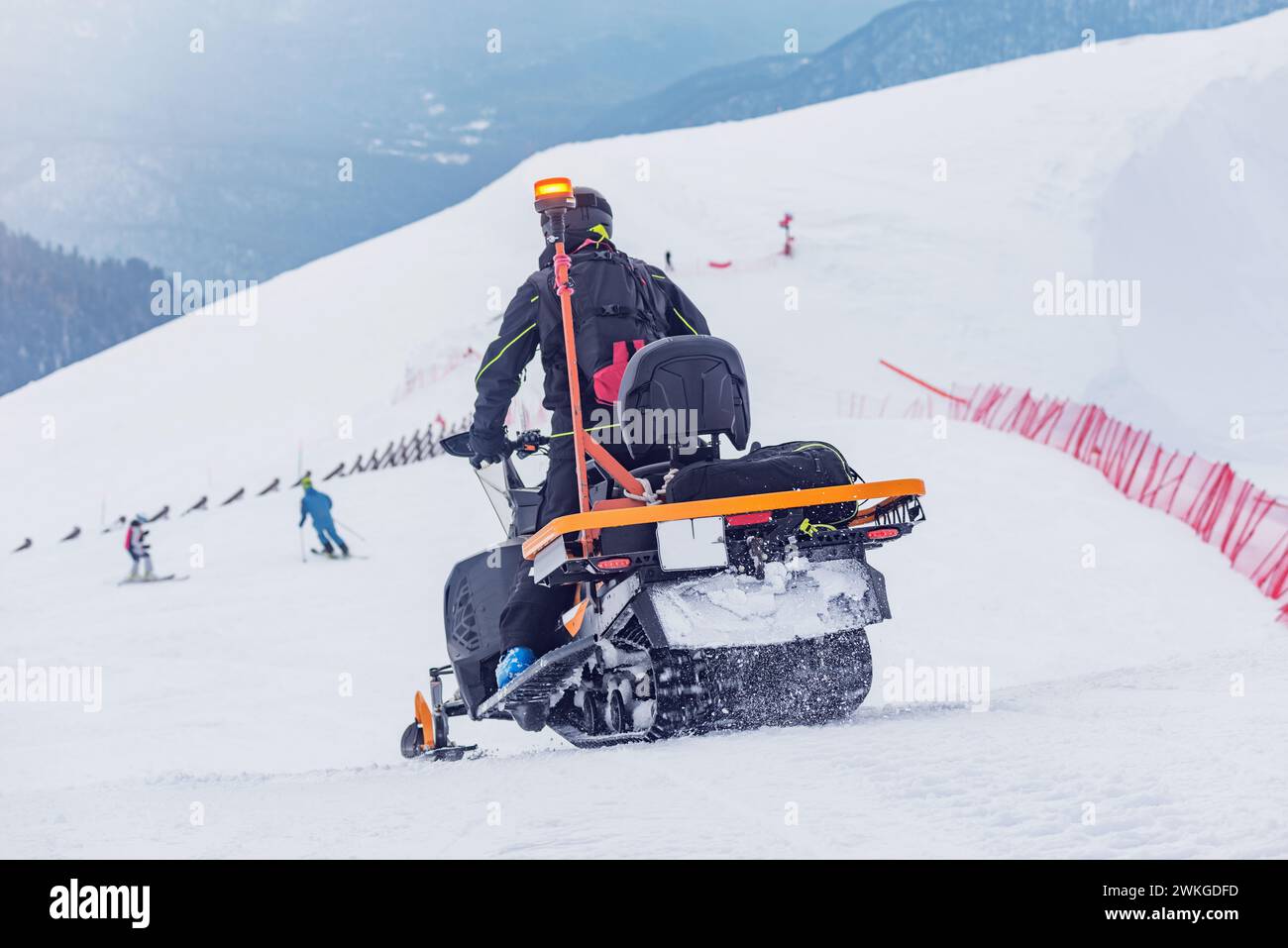 Rescuer man driving snowmobile on the ski resort Stock Photo - Alamy
