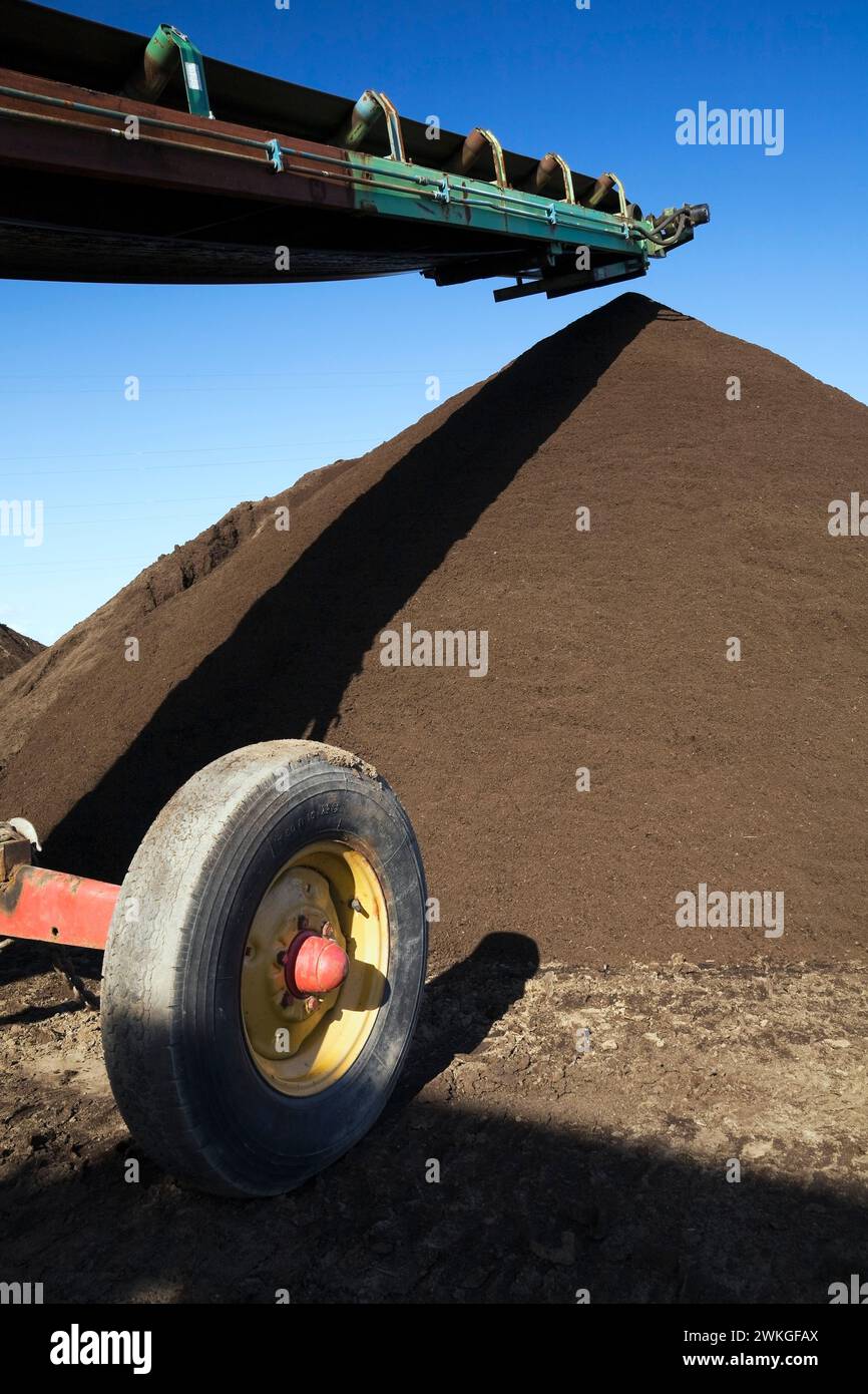 Stacking conveyor and mound of brown topsoil in commercial sandpit ...
