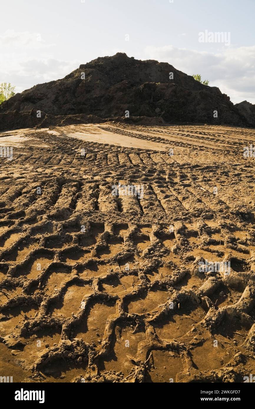 Heavy tire tracks and mound of sand mixed with soil in commercial ...
