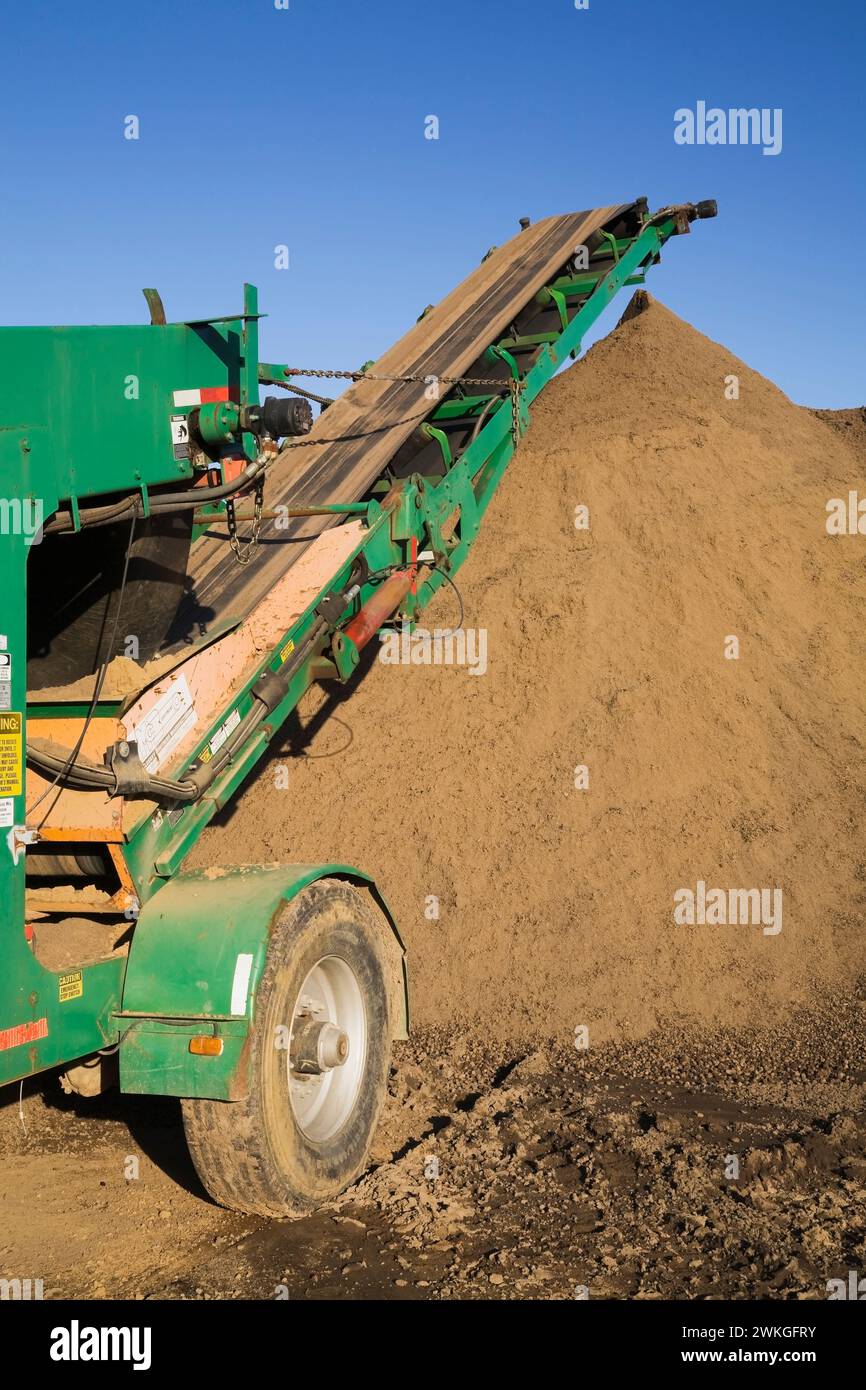 Green stacking conveyor and mound of tan colored sand in commercial ...