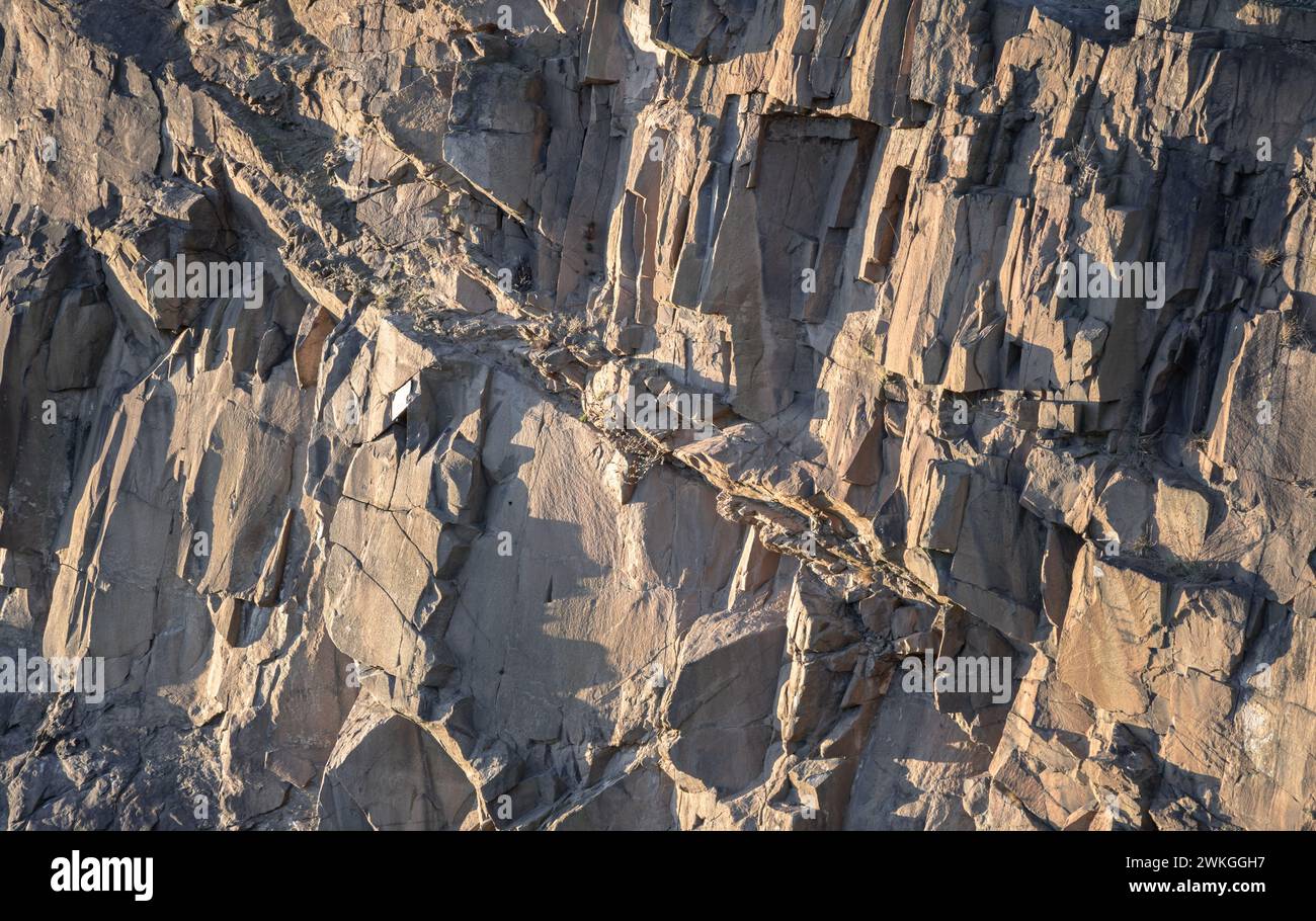 Crumbling rock cliff wall texture with cuts and shadows of The granite ...