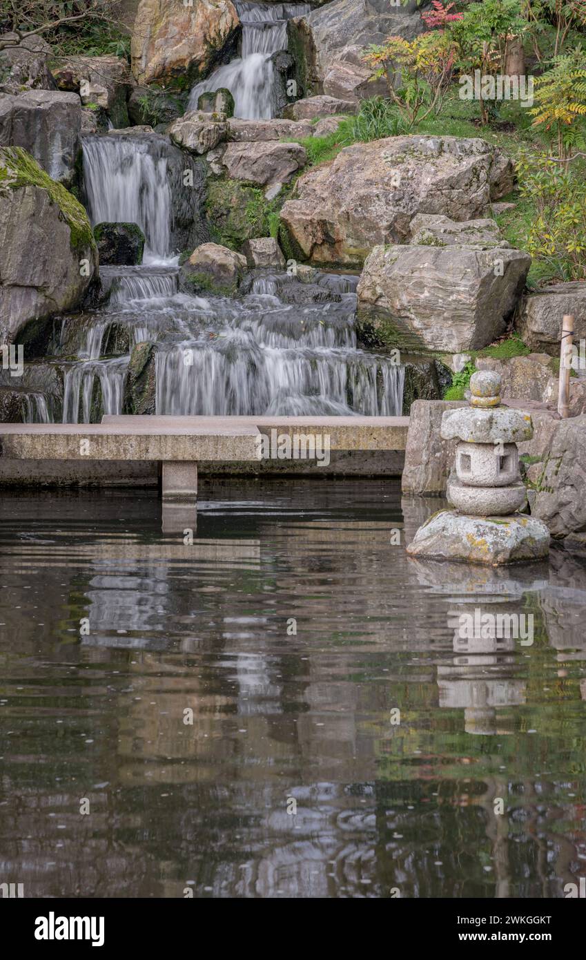 Decorative japanese stone lantern in front of with orange maple trees ...