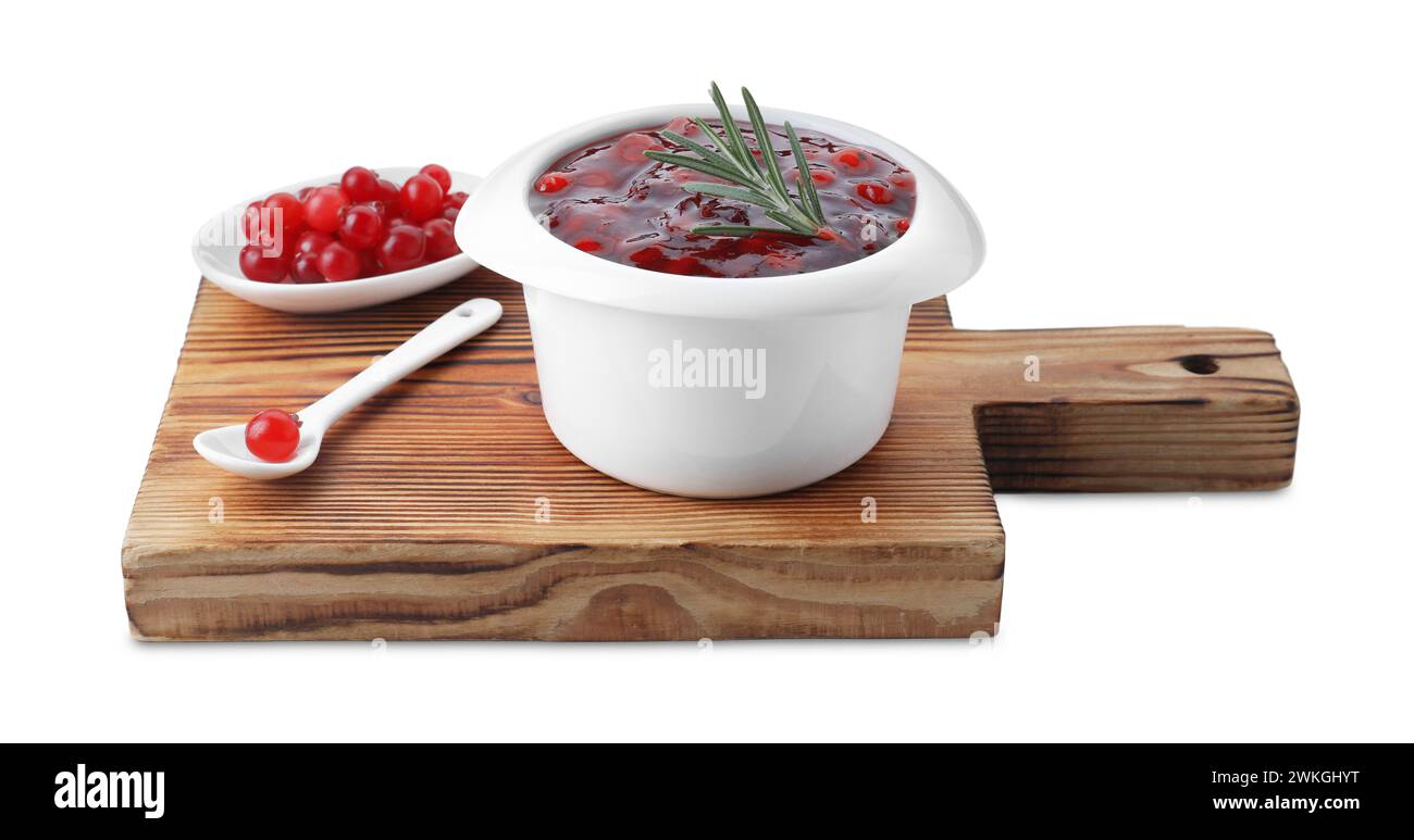 Wooden board with cranberry sauce, fresh berries, spoon and rosemary ...