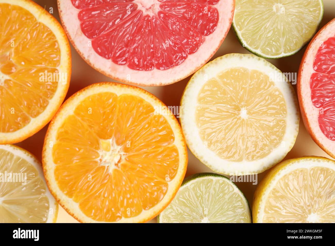 Different cut citrus fruits on beige table, flat lay Stock Photo - Alamy