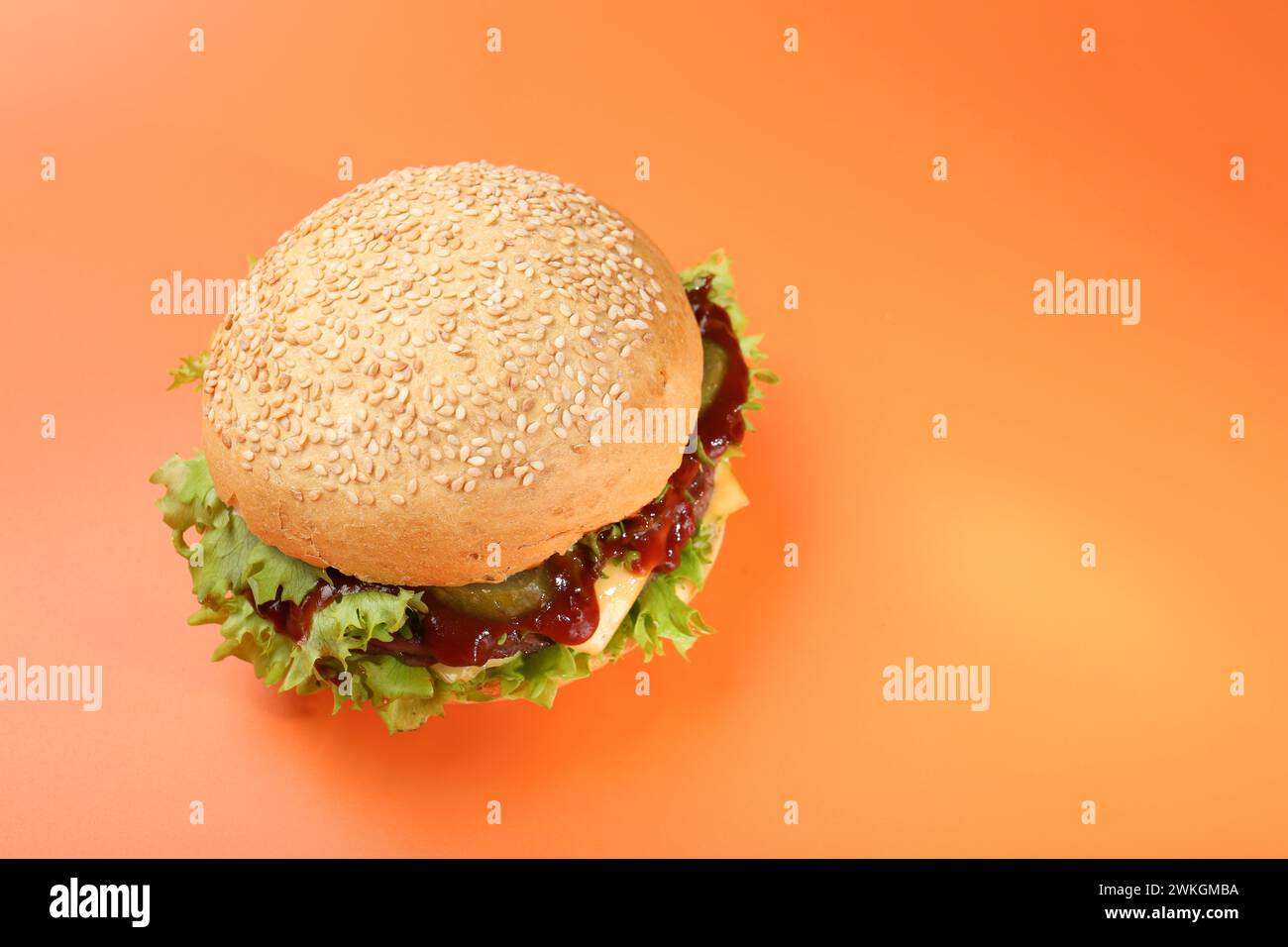 Delicious cheeseburger on coral background, above view. Space for text ...