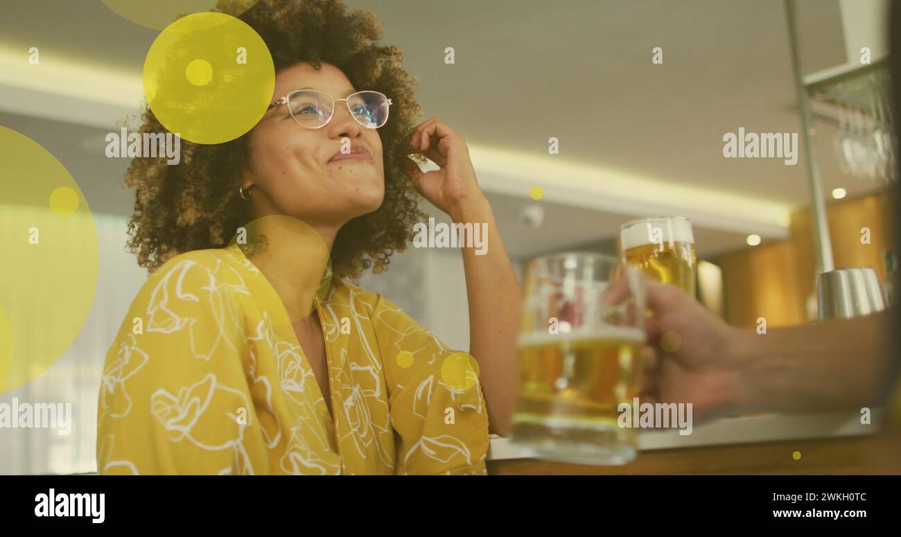 Image of spots over happy biracial woman with caucasian friend drinking ...