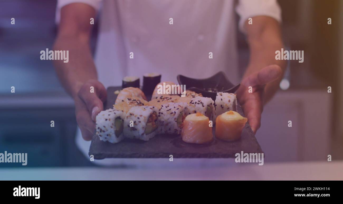 Image of biracial male chef holding sushi Stock Photo - Alamy