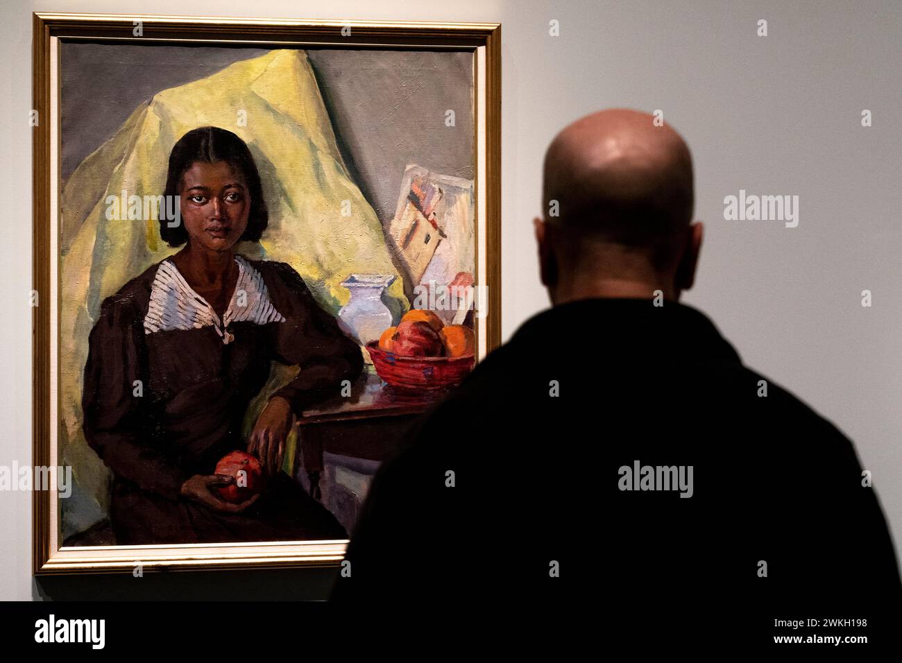 A visitor looking at paintings by Laura Wheeler Waring 'Girl With ...