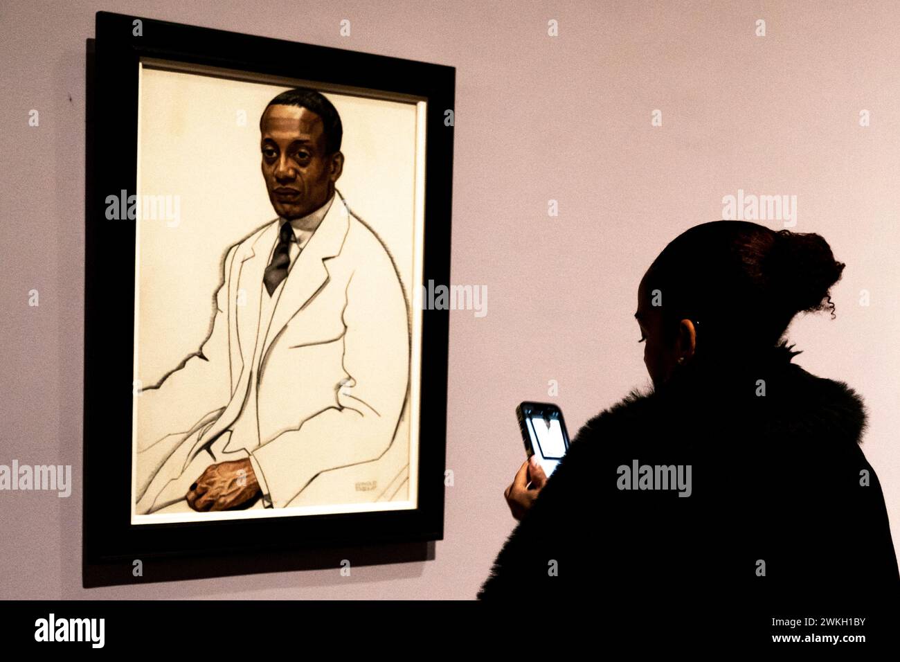 A visitor takes a photo of portrait of Alain Leroy Locke by Winold ...