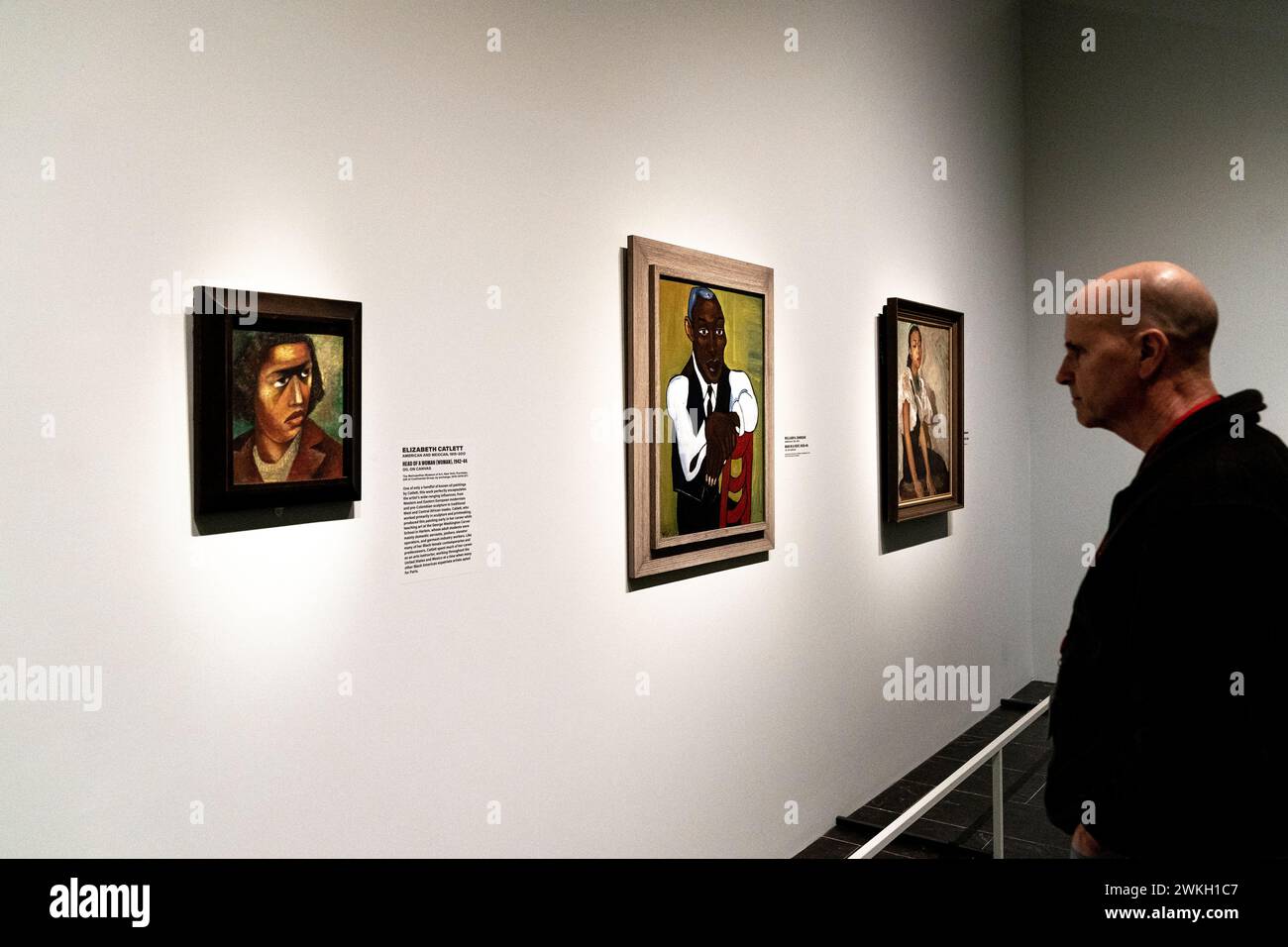 A visitor looking at paintings by William H. Johnson 'Man in a Vest' on ...