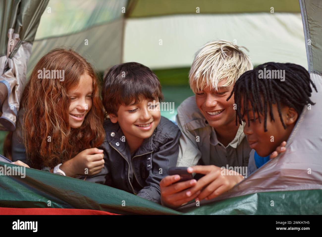 Phone, happy and children in tent for camp networking on social media ...