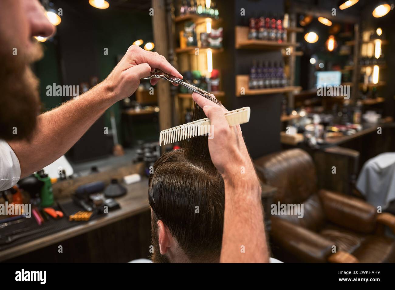 Close-up photo of barber cutting wet hair. Professional hairdresser ...