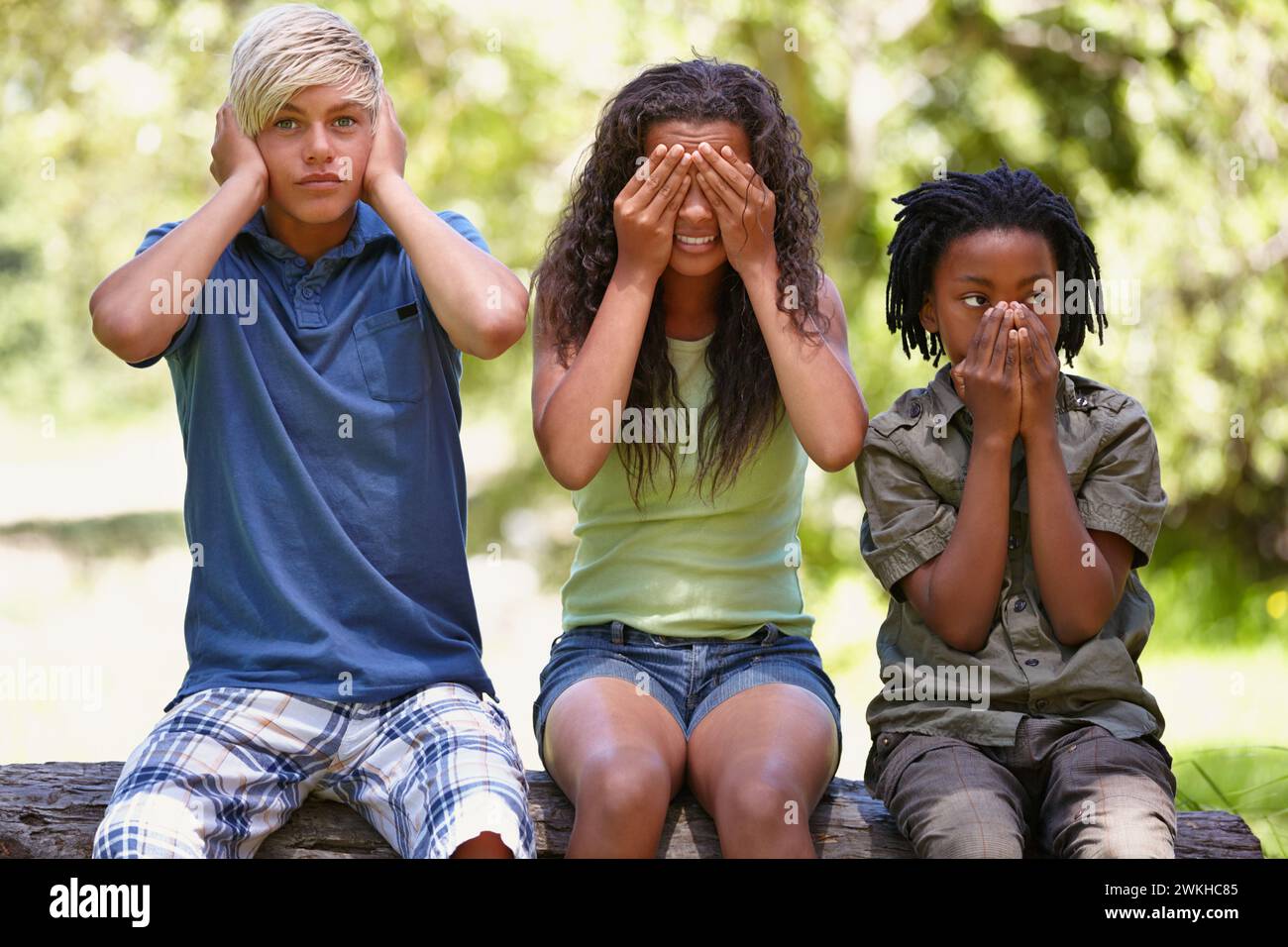 Kids, see and hear or speak no evil, forest bench and sitting down for ...