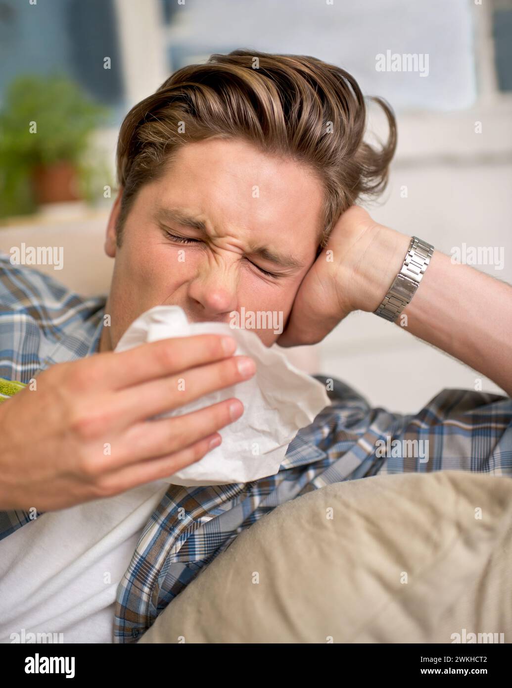 Sick, flu or man sneezing into tissue on sofa with cold, virus or hay ...