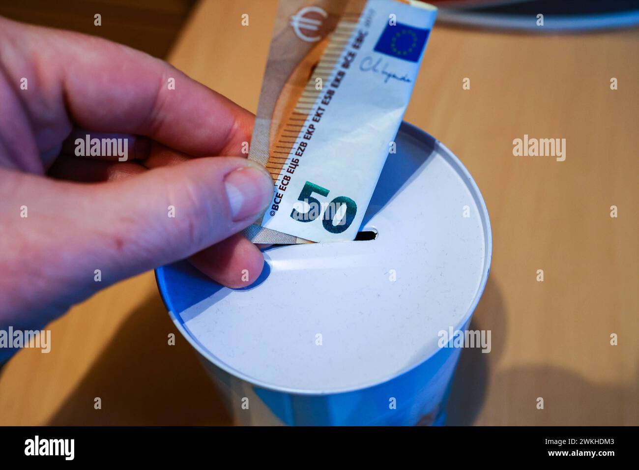 50 Euro Schein am Schlitz einer Spardose *** 50 euro bill in the slot ...