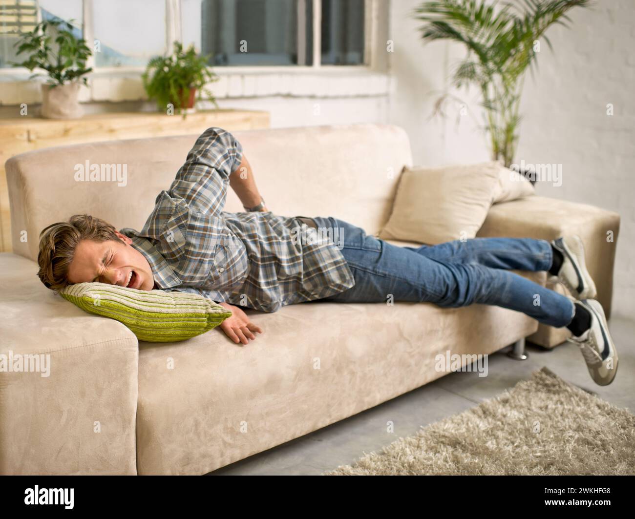 Back pain, stress and screaming man on a sofa with emergency, problem ...