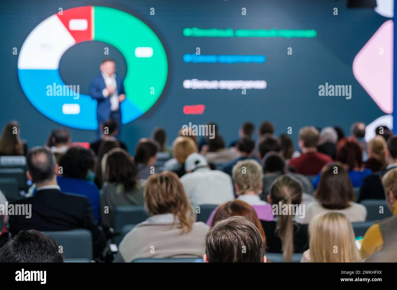 Focused audience at a business conference listening to a presenter with ...