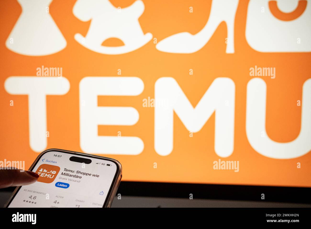Handy mit geöffnetem App Store für TEMU-Download vor Logo-Hintergrund ...