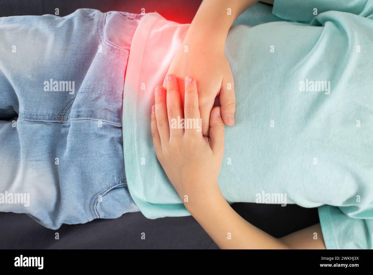 A little girl lies and holds her stomach, which hurts. Concept of ...