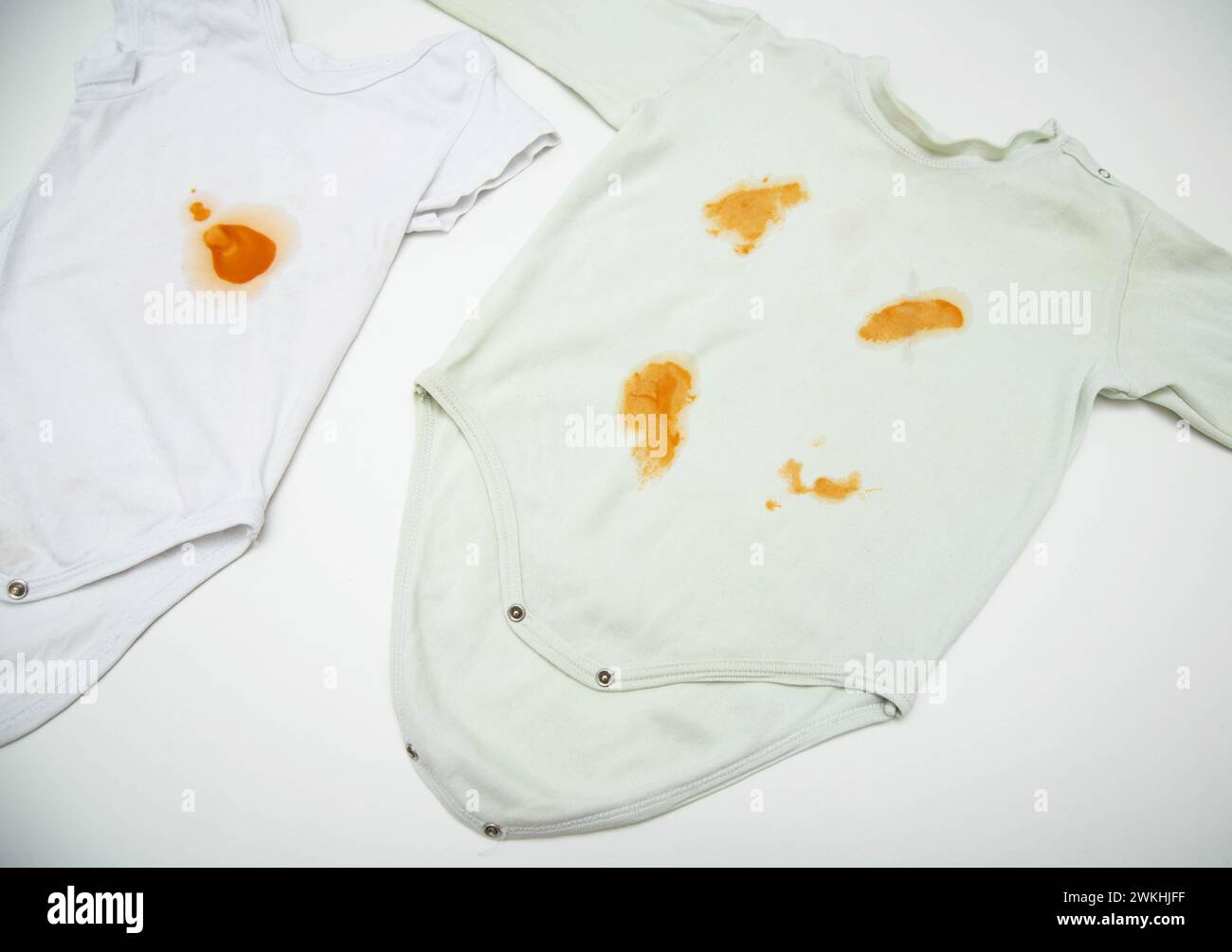 Orange stains on children's clothes from fruit puree. The concept of ...