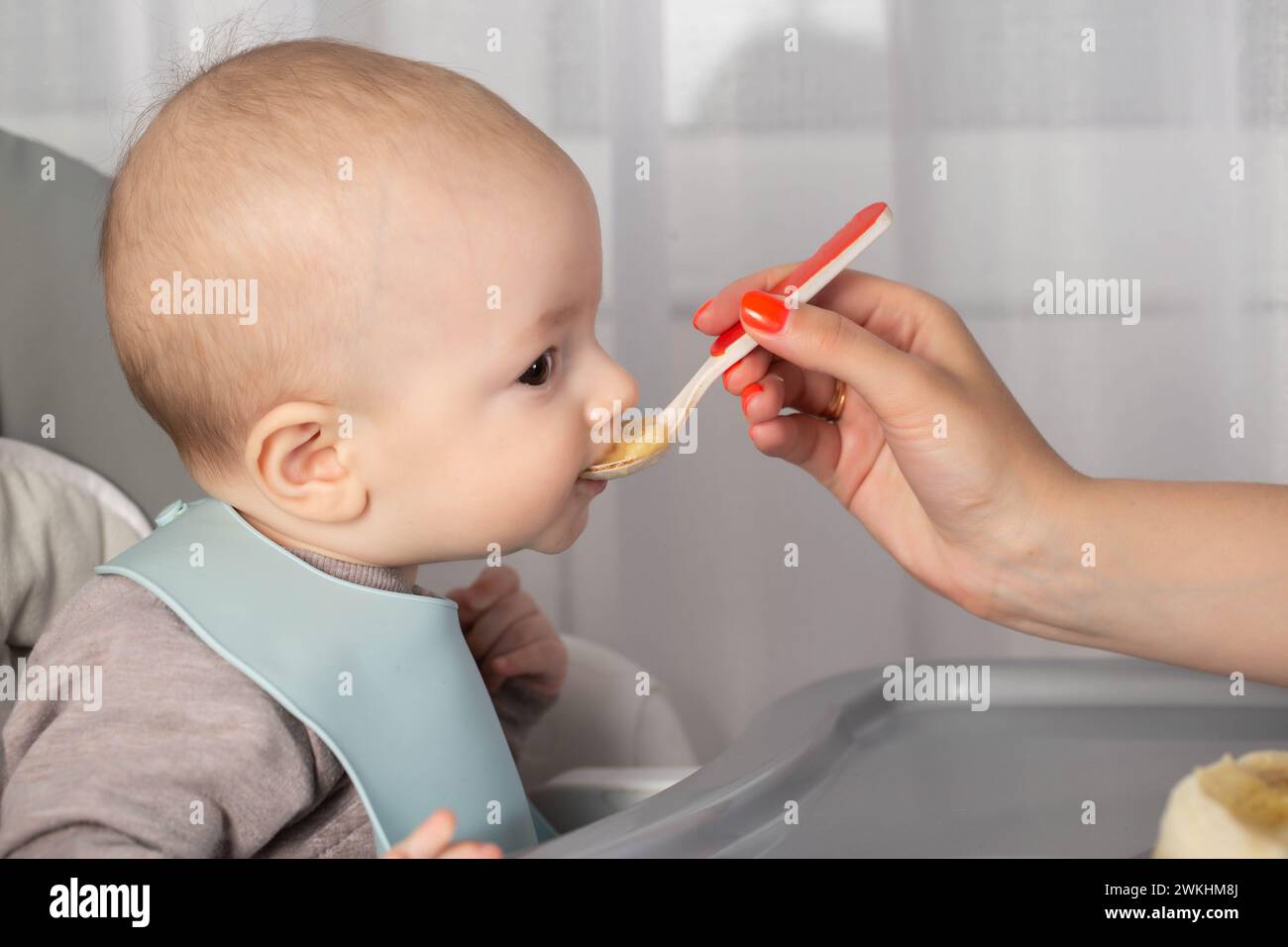 Feeding porridge and puree of a small child from a spoon. First meal ...
