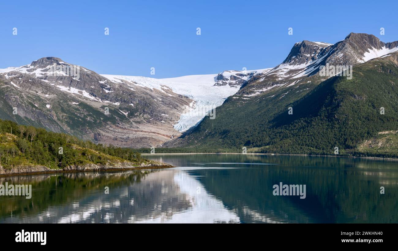 A panoramic display of the Svartisen Glacier descending into lush ...