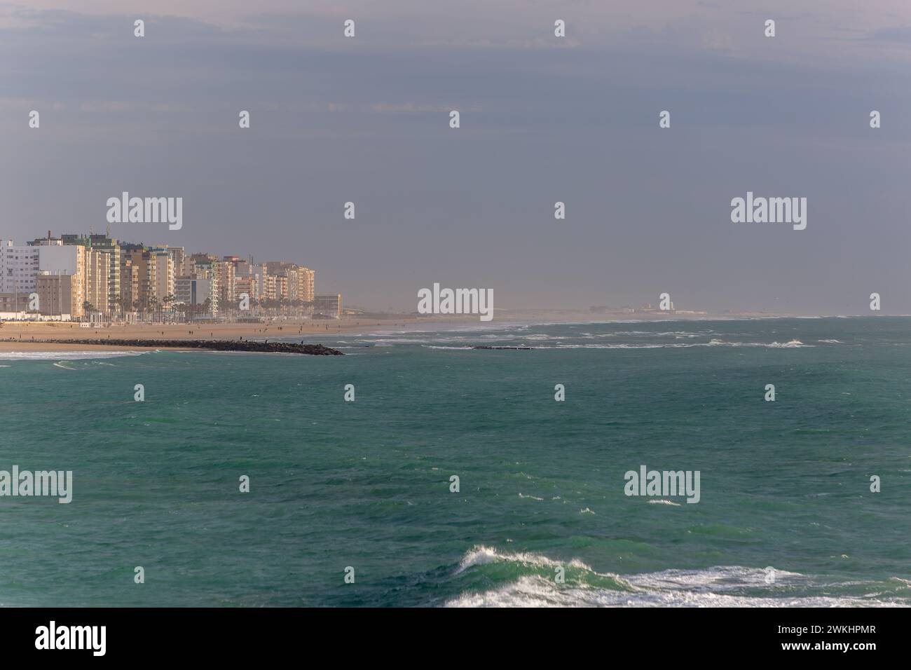 A scenic view of a beach with prominent shoreline buildings in Spain ...