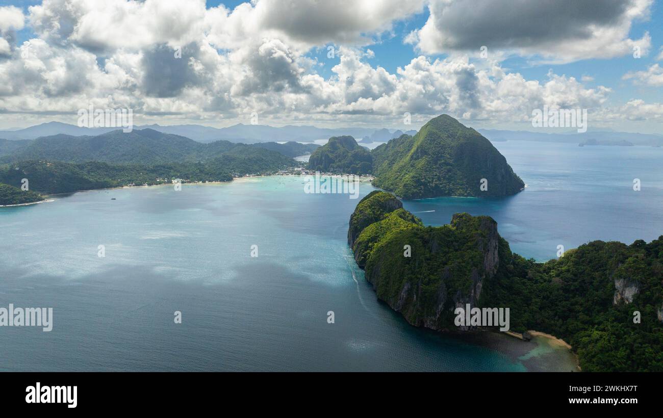 Coastal town in El Nido. Boats floating over the sea under blue sky and ...