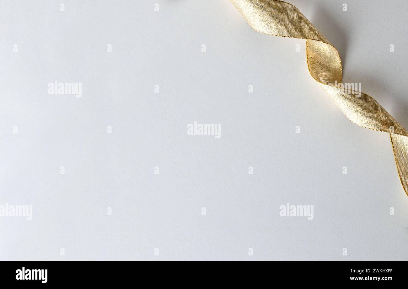 Shiny gold ribbon in corkscrew in upper right corner on white isolated ...