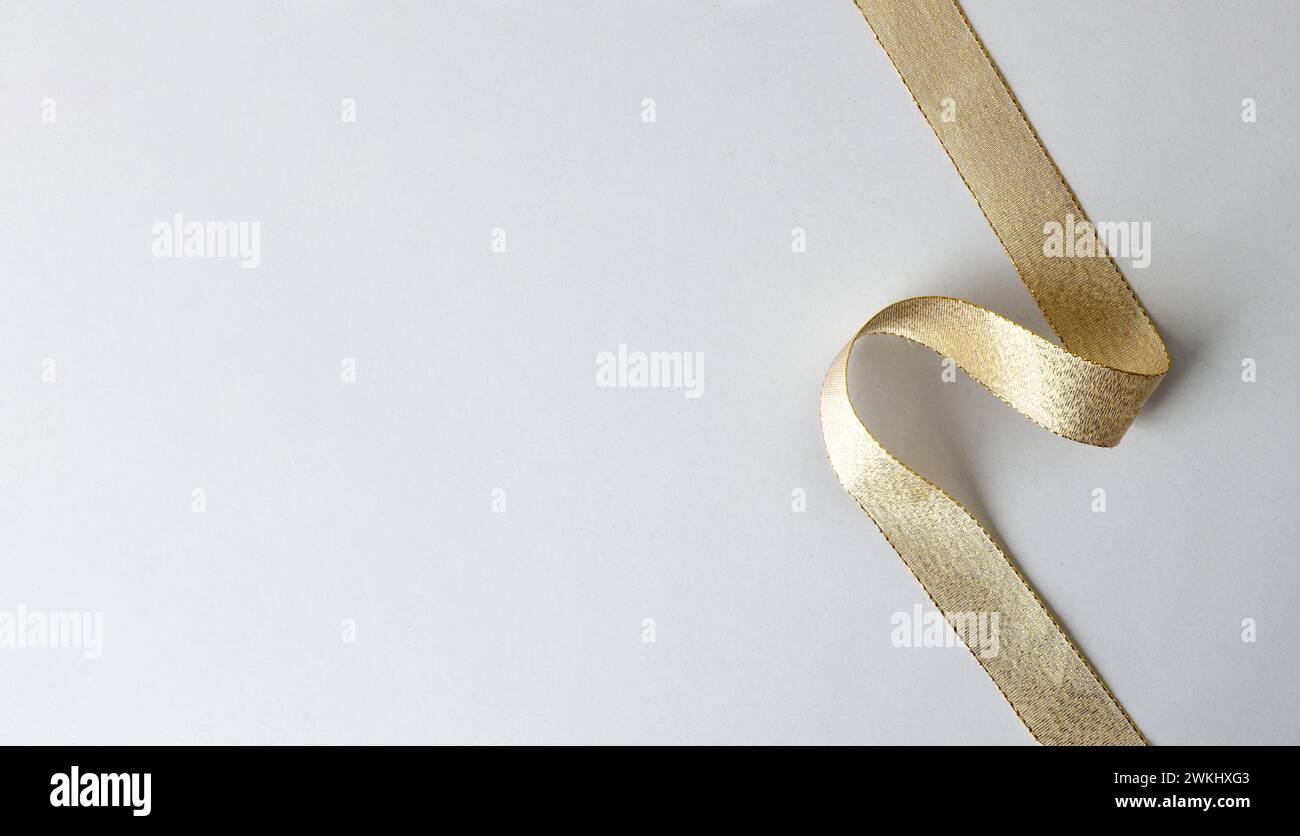 Shiny golden textile ribbon making curves in the center placed on the ...