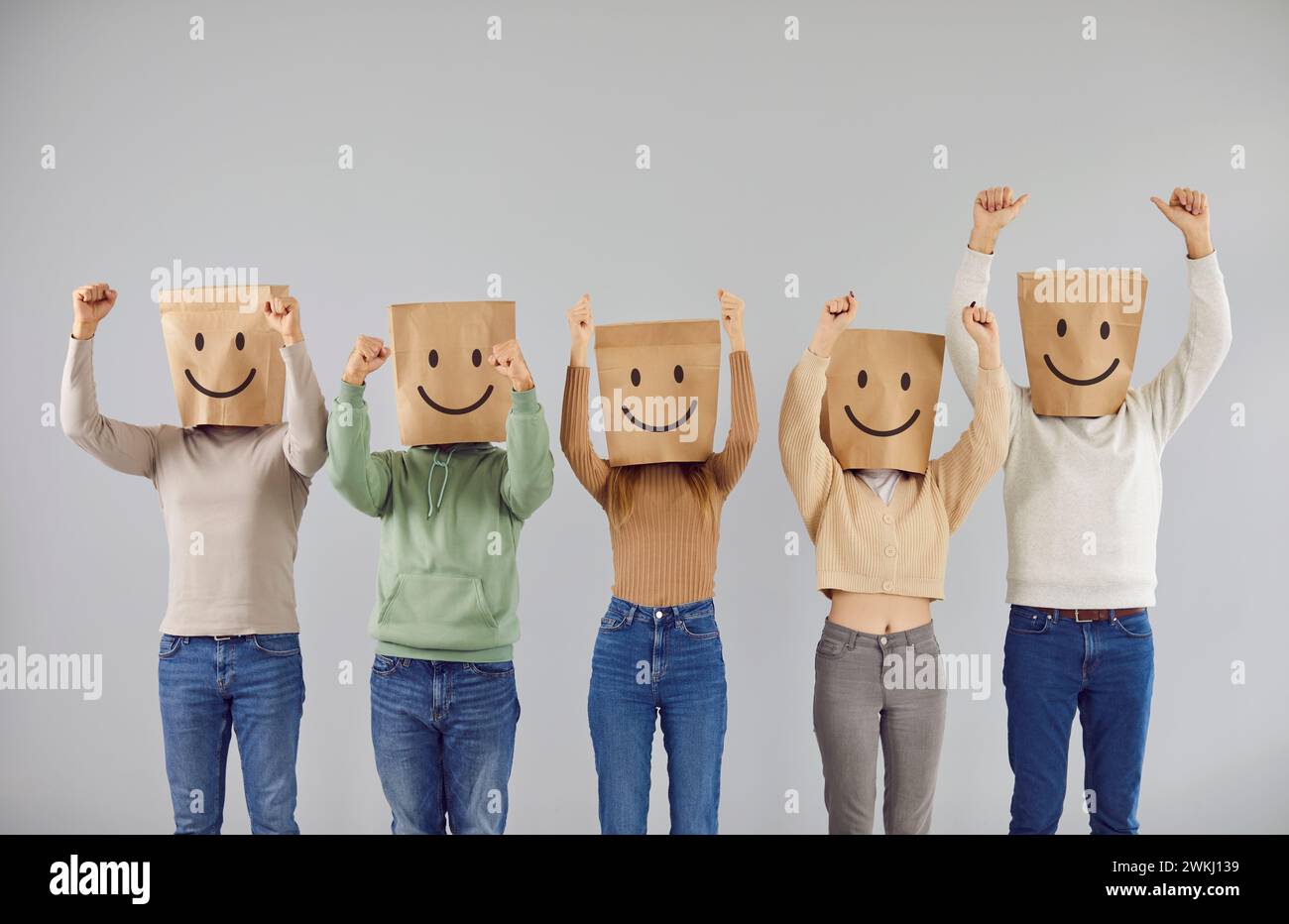 Creative people wearing bags with happy emoticons on their heads ...