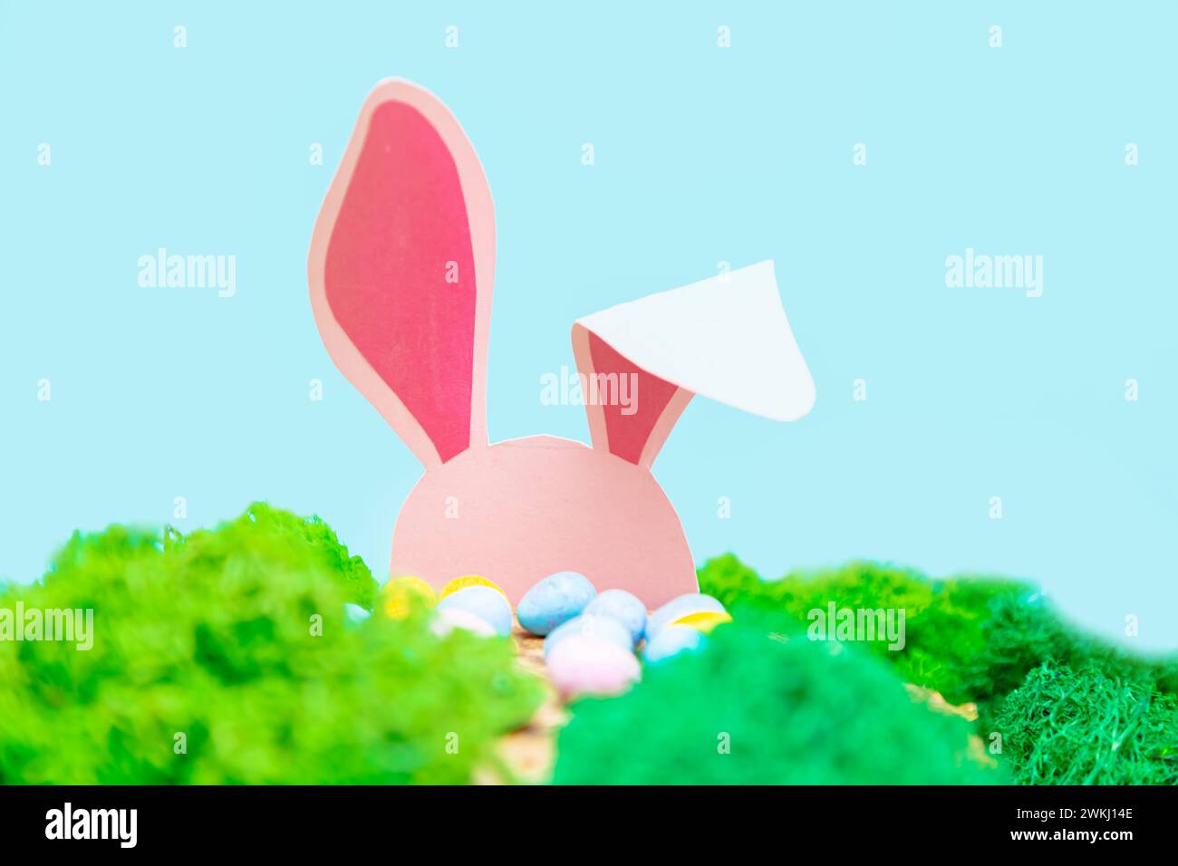 The pink rabbit is hiding in the grass. Easter greeting card with ...
