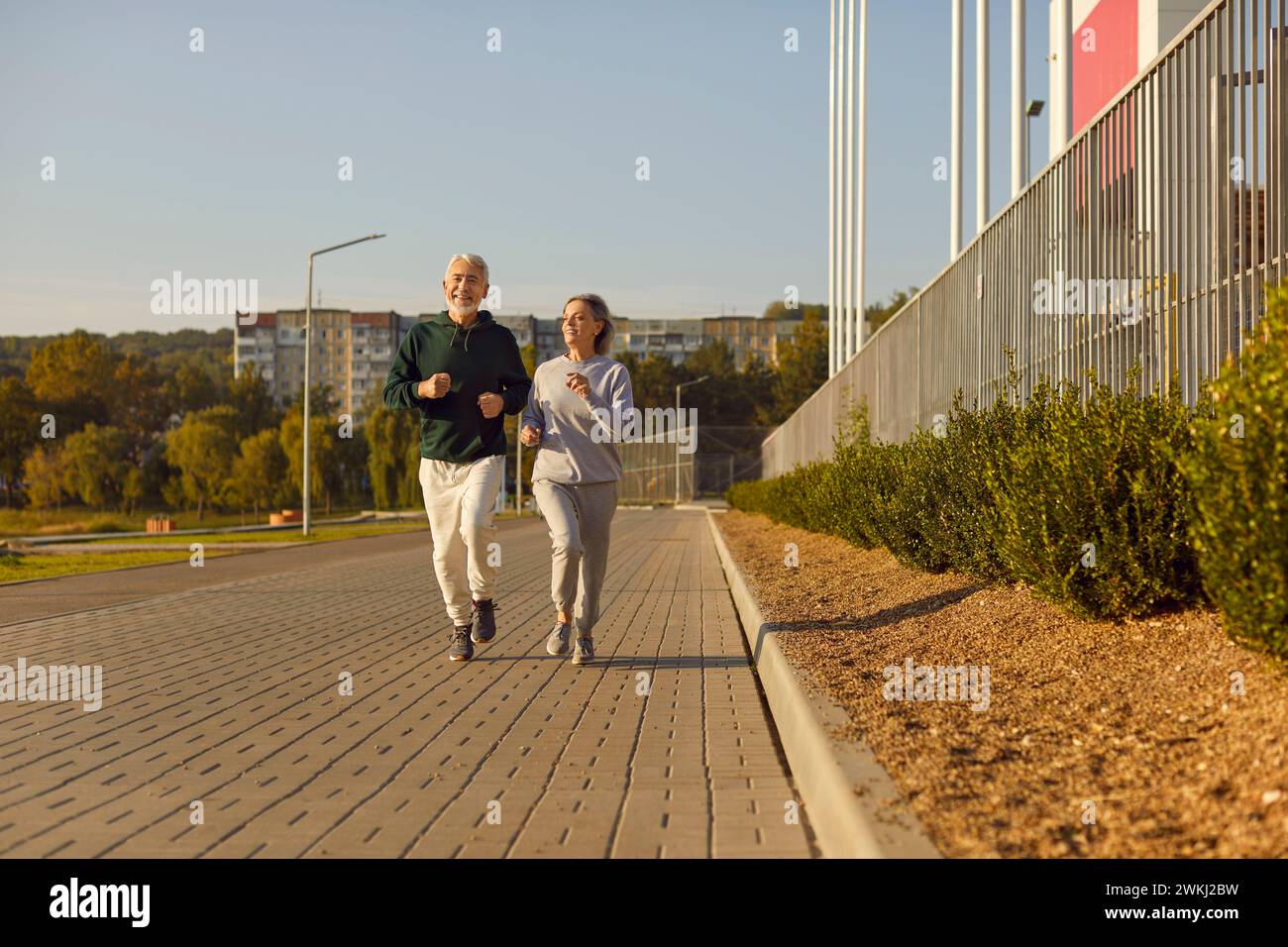 Senior couple jogging in park having sport workout in nature together ...