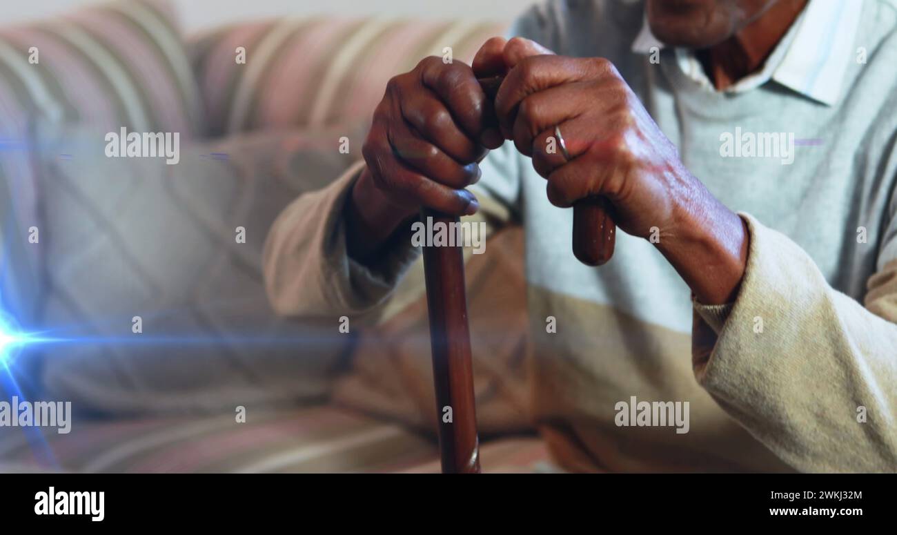 Image of light moving over senior asian man at home on couch using ...