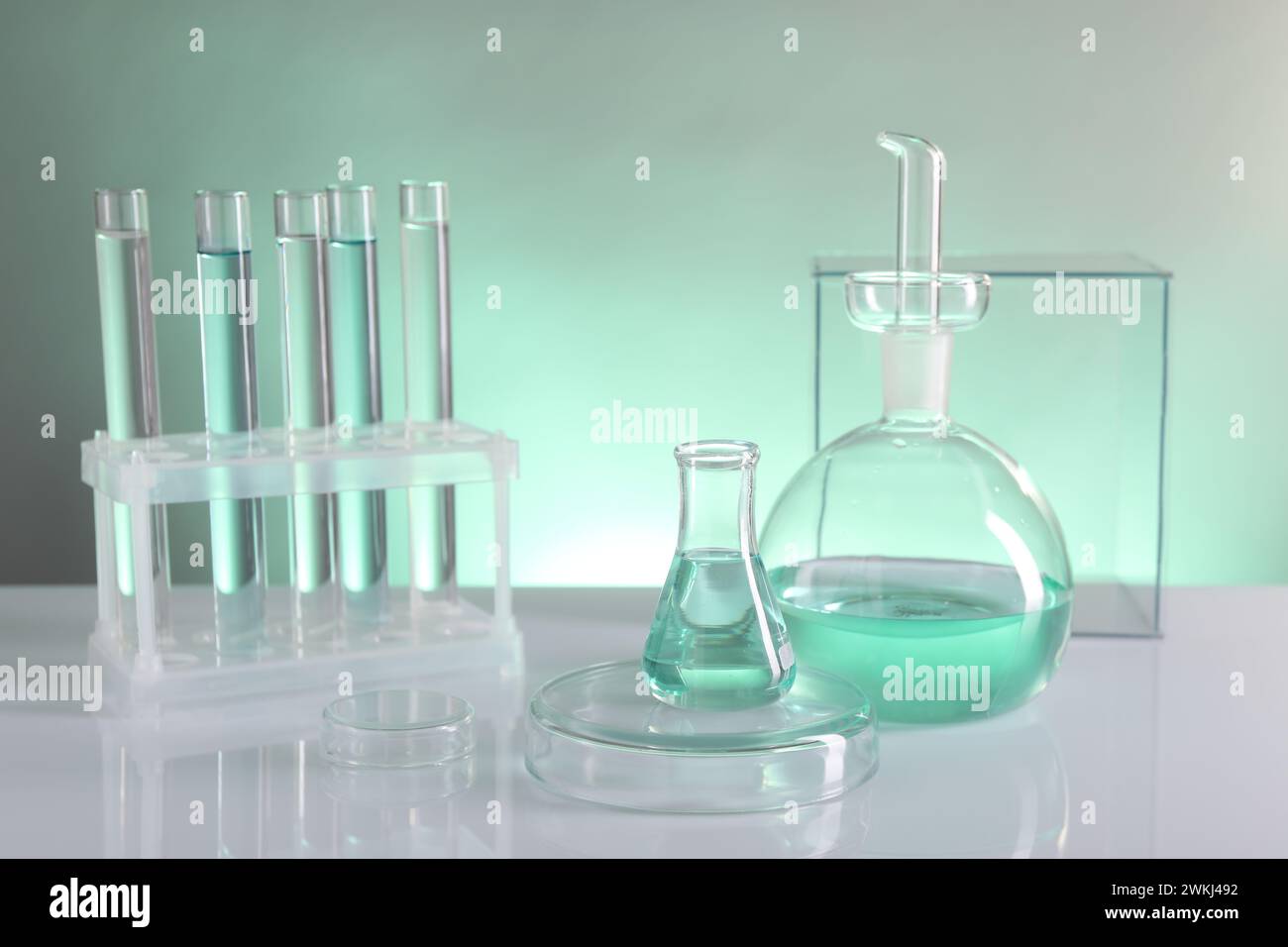 Laboratory analysis. Different glassware on table against color ...