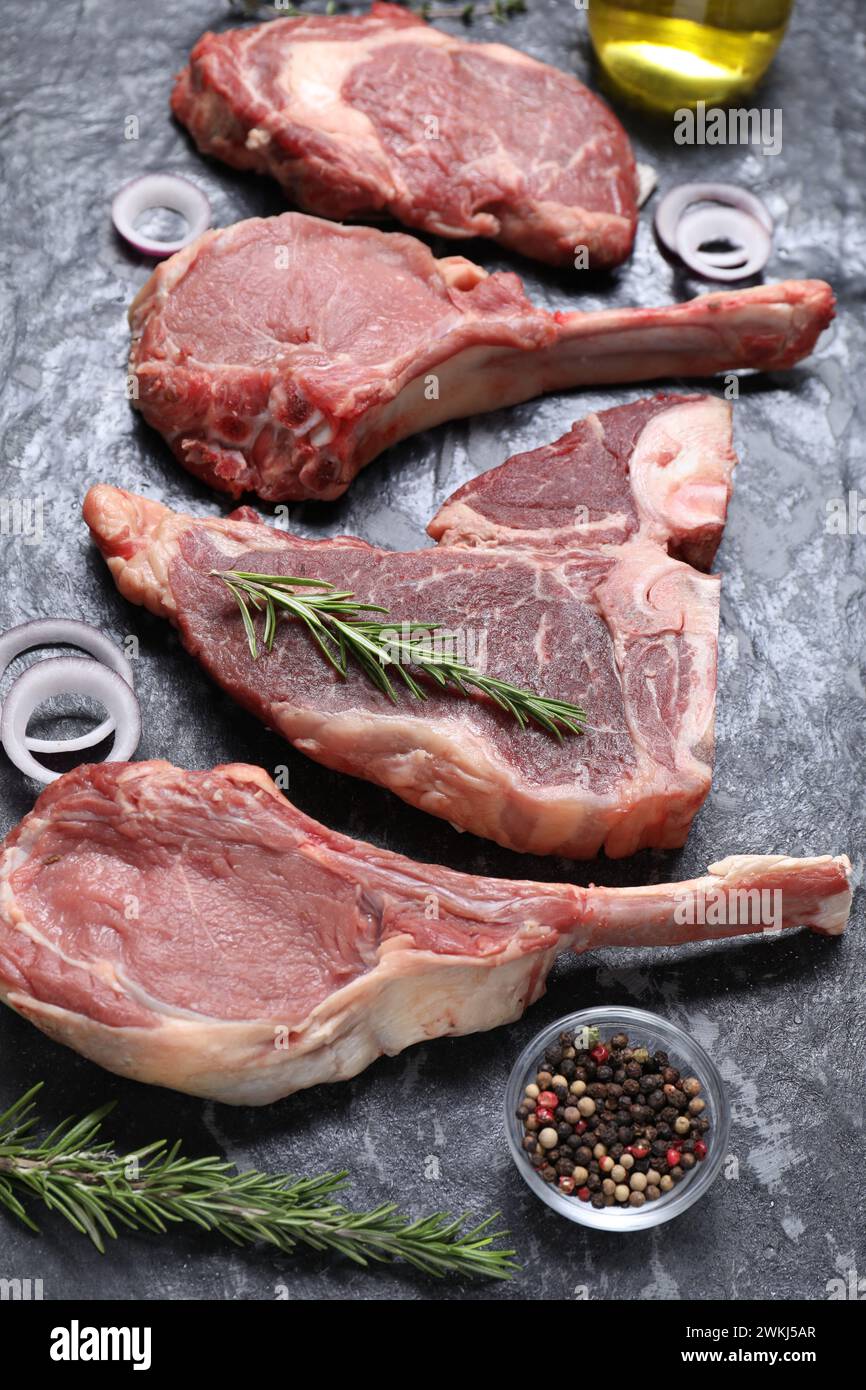 Fresh raw beef cuts and different spices on grey textured table Stock ...