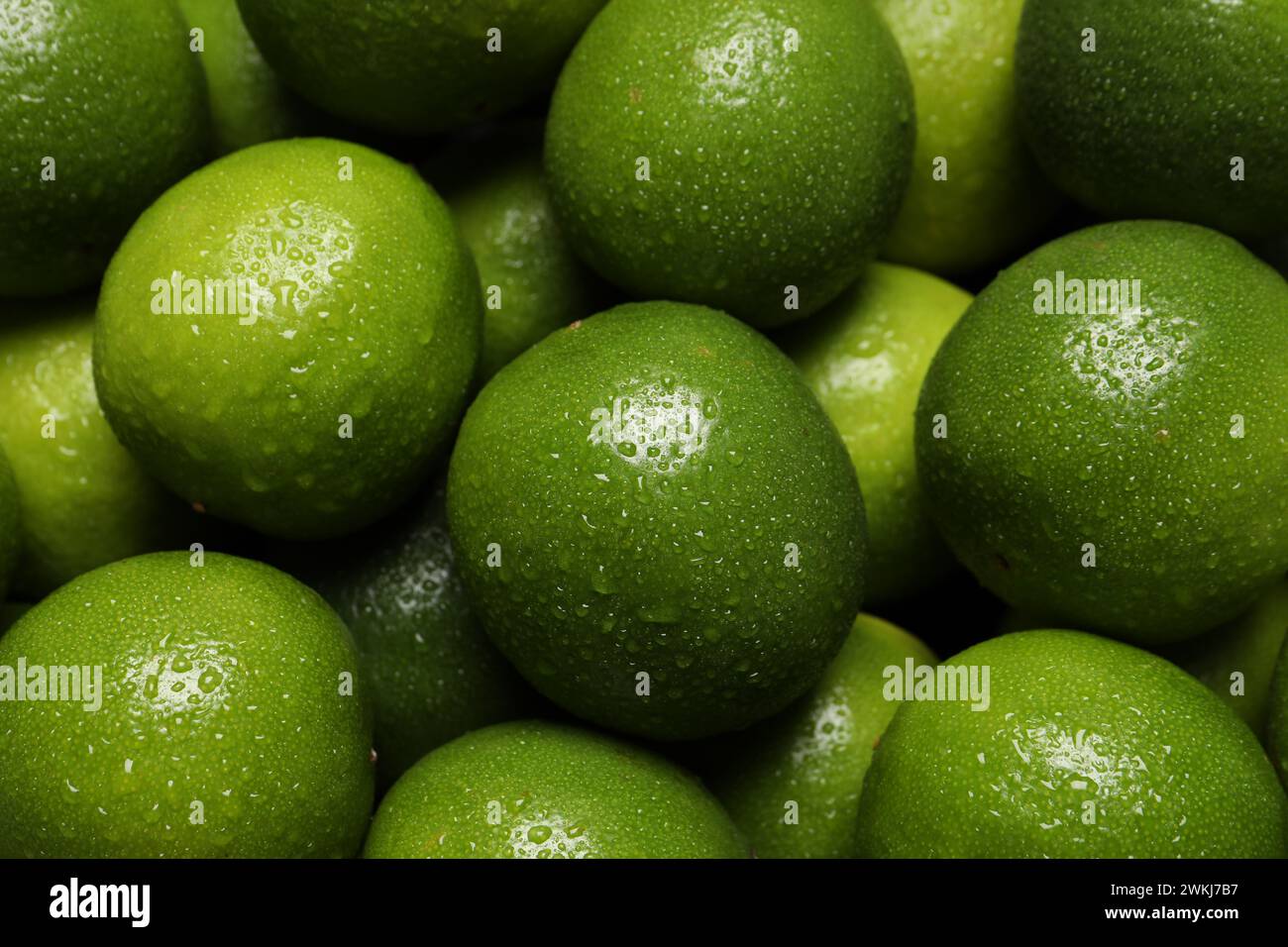 Fresh ripe limes with water drops as background, closeup Stock Photo ...