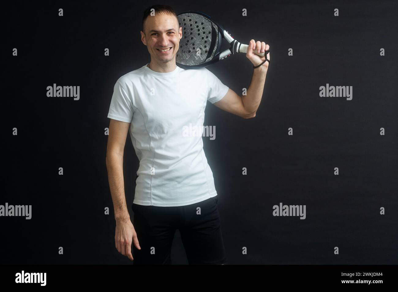 Portrait of man playing paddle tennis in position to hit a backhand ...