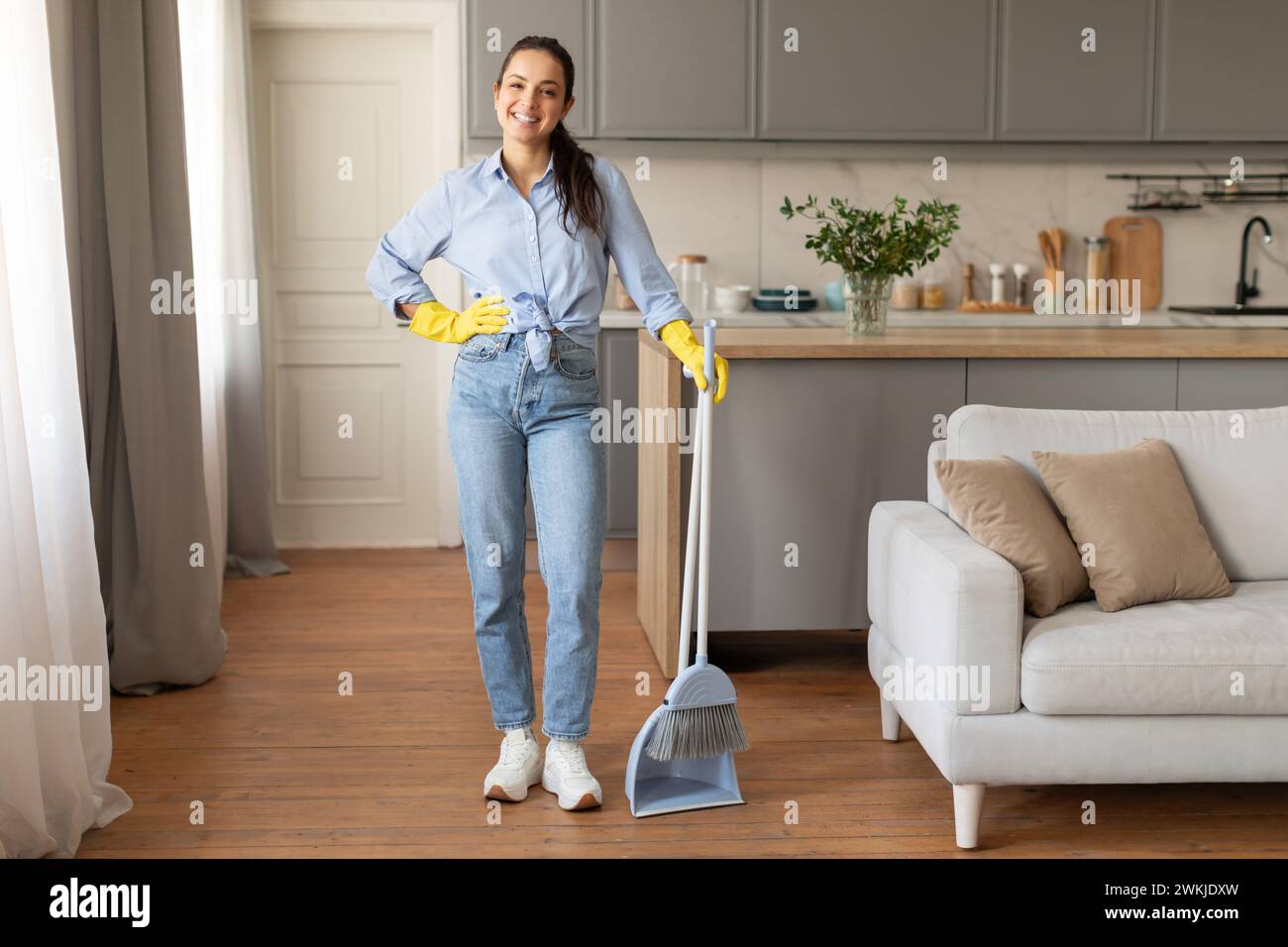 Confident woman with broom ready to clean house Stock Photo - Alamy