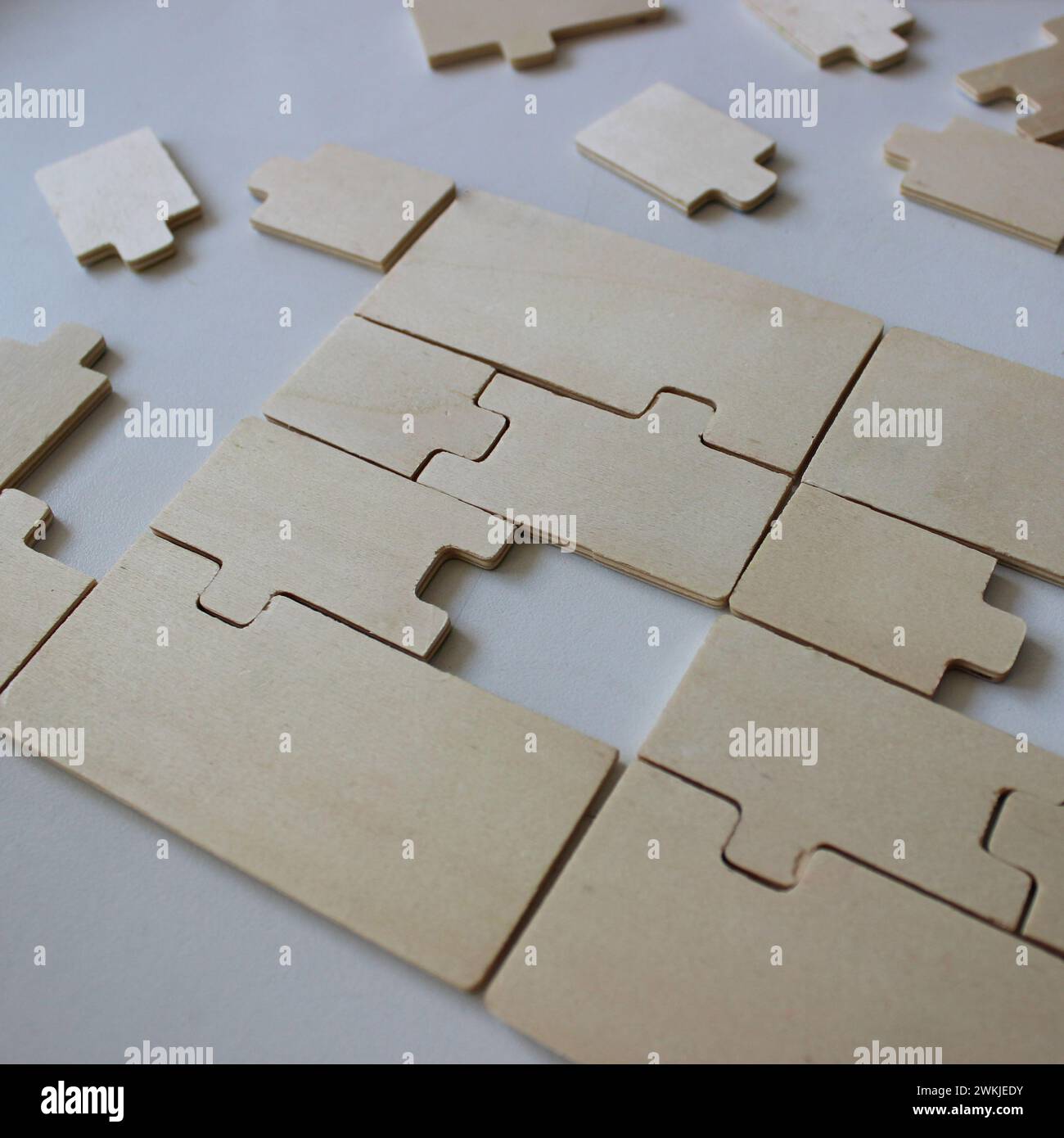 Several missing pieces in a nearly complete puzzle made from wooden fragments Stock Photo - Alamy