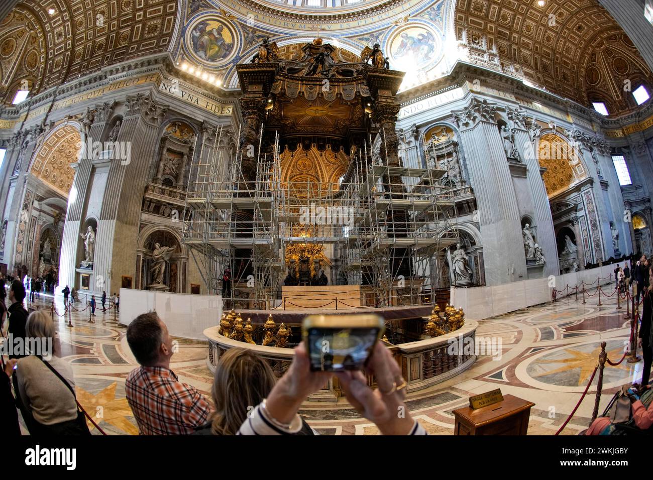 A person takes photos in front of the scaffolding surrounded 17th ...